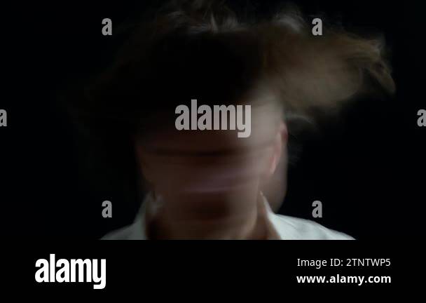 A man in a shirt with long hair shakes his head and shakes his hair to ...