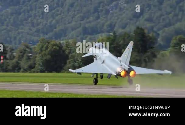 Fighter Jet Takes Off from Runway in a Narrow Alpine Valley with Green ...