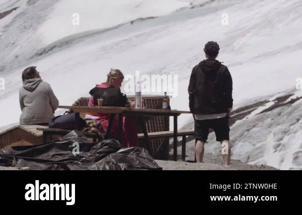 Filming crew relaxing at at table on mountains trail campsite Stock ...