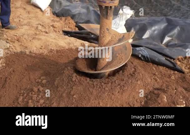 Digging holes for planting fruit seedlings. Man Operate Hydraulic Post ...