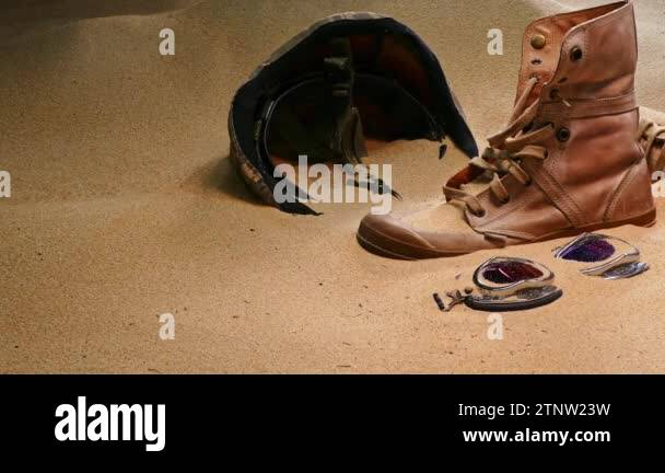 Parts of a soldier's uniform lay in the sand. Ruins after the war ...