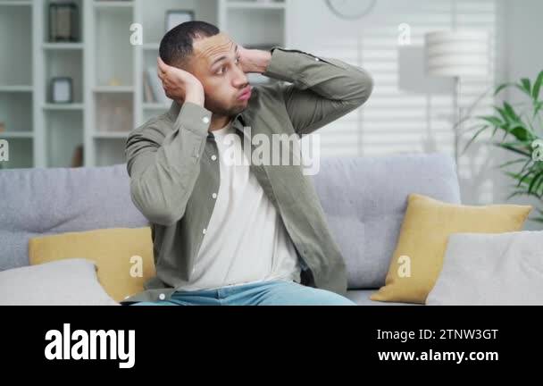 Tired man suffers because of noisy neighbors. Poor soundproofing in the ...