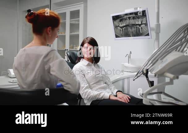 Beautiful girl consulted a dentist in his office ball on the thymus of the pain pointing to her ...