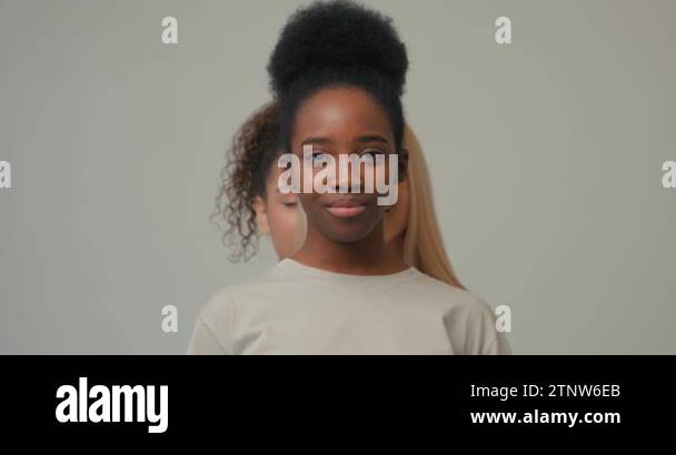 Multi-ethnic girls standing behind African American woman hiding ...