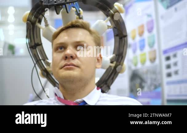 Man wired to an EEG machine or electroencephalograph which produces a ...