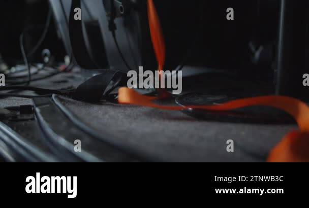 Fixing objects inside helicopter by ratchet strap. Threading the orange belt through the fixing ...