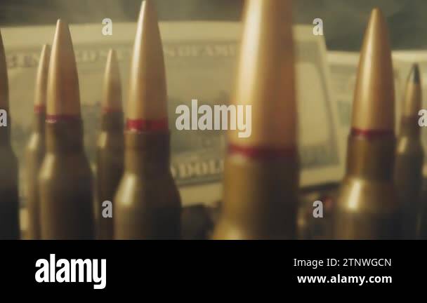 Rows of rifle cartridges on the background of dollar bills close up. Rifle ammunition is ...