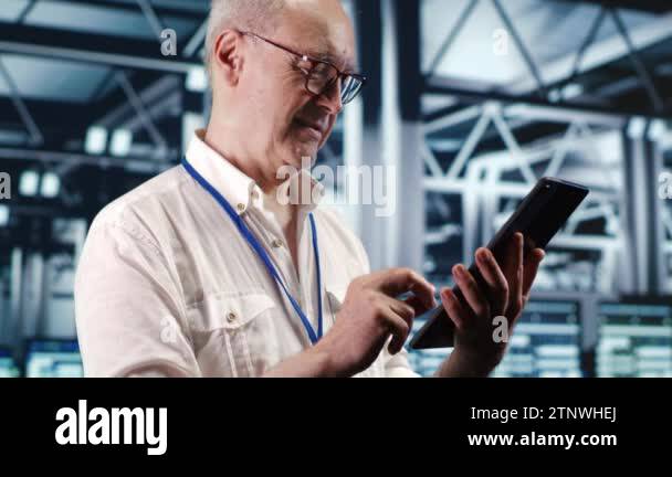 Engineer in high tech data center using tablet to monitor energy ...