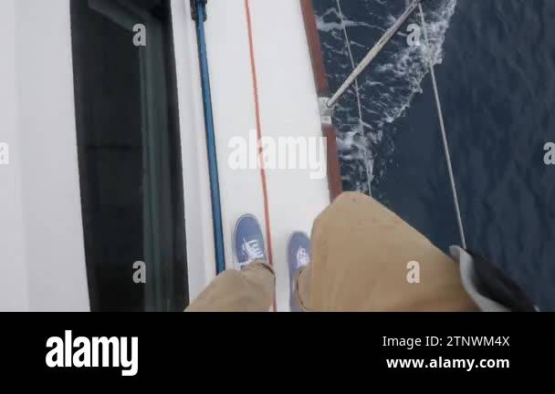 Legs feet of man walking along deck of white luxury yacht boats ship of ...