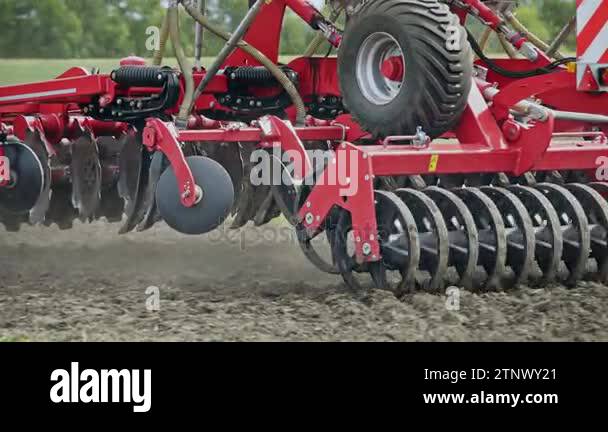 Sowing machine working on farming field. Farming tractor with trailer ...