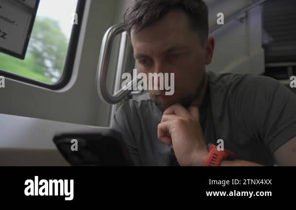 Young man travels on double decker train and sits on flyer using his ...