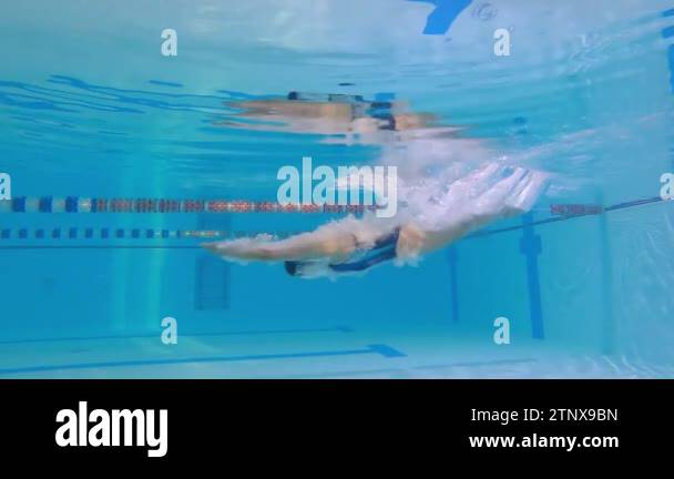 Woman athlete swims underwater in the pool. Slow motion of a female ...