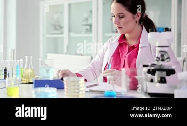 Rotating substance in glass of liquid in laboratory scientist conducts ...
