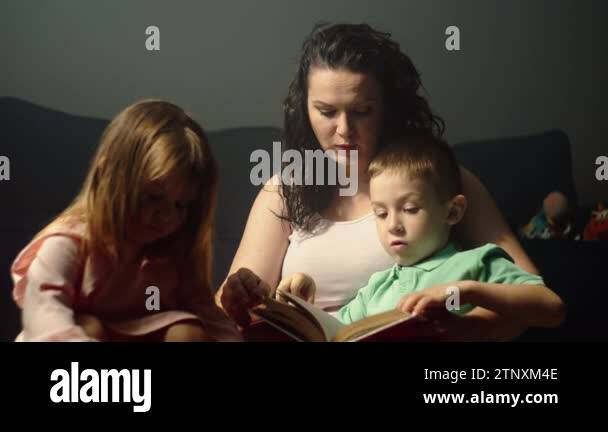 Mom is reading a fairy tale book for children. A happy family with ...