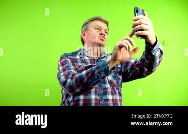 Funny senior caucasian man taking silly selfie using his smartphone ...