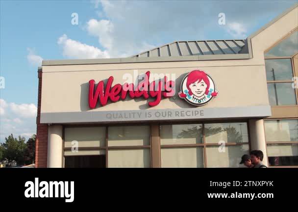 wendys restaurant logo on building store above windows exterior outside in summer on bright day ...