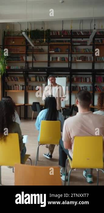 Laughing grey haired male teacher lectures to multinational students in ...