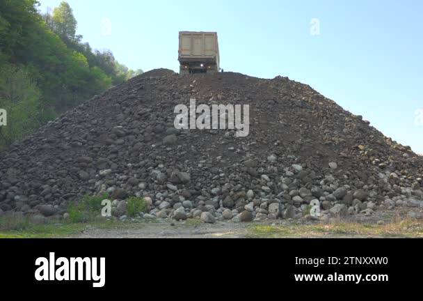 Dump truck unloading sand stone and gravel mix. Large big road material ...