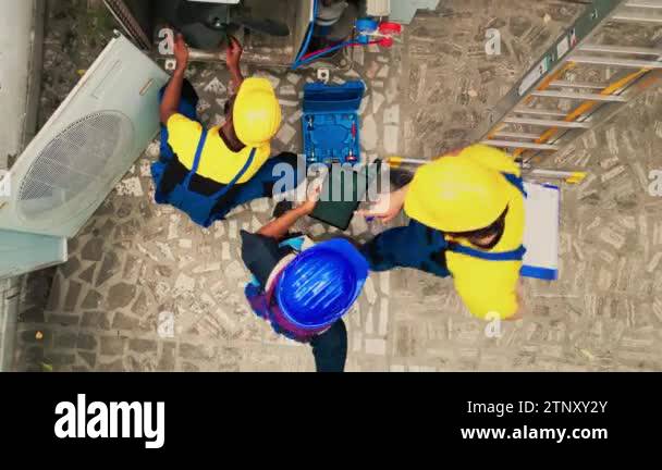 Dolly out drone shot of efficient technicians cleaning and lubricating ...