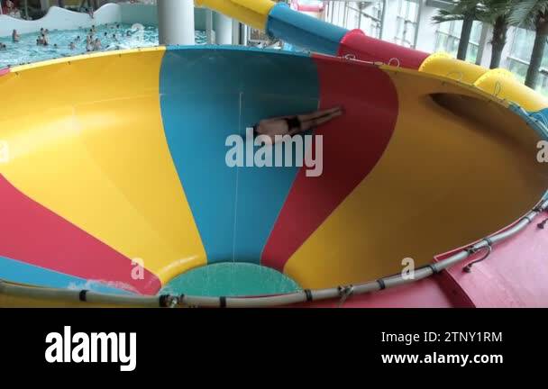 A young man slides down from a water slide in a water park water park ...