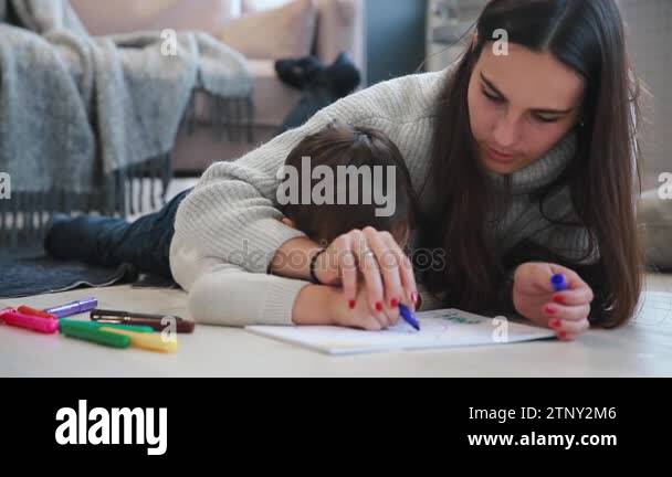 Beautiful young mother in a warm sweater lying on the floor with my son ...