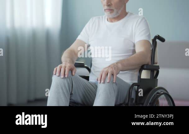 Helpless man with disabilities sitting in wheelchair, turning back to ...