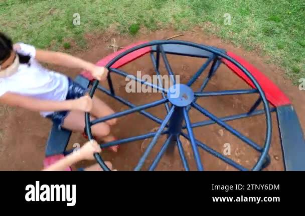 Small girls playing in playground carousel roundabout in motion Stock ...