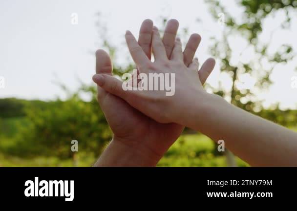 Two people holding hand together over blurred nature background ...
