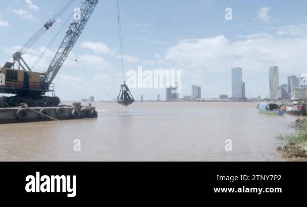 Bucket dredge mounted on a barge remove sediment from one part of a ...