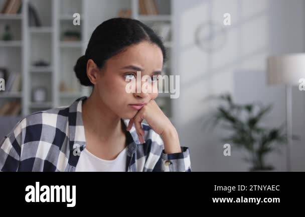 Attractive African American girl sitting in living room, resting hand ...