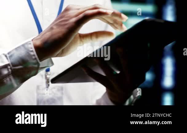 Close up shot of mechanic using tablet to find flaws in data center ...