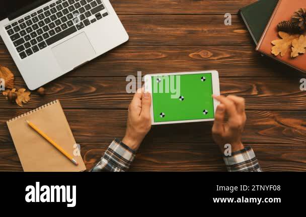 Man tapping on the white tablet device with green screen. Horizontal ...