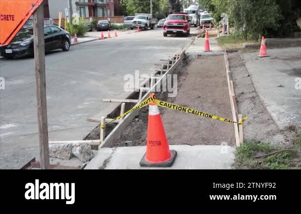 sidewalk construction building dug out up with wood frame and pylons ...