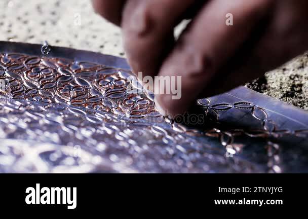 Traditional tinsmith work. Copper smith makes embossing artifacts from ...