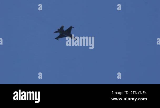 NATO fighter jet performs inverted flight in blue sky, showcasing ...