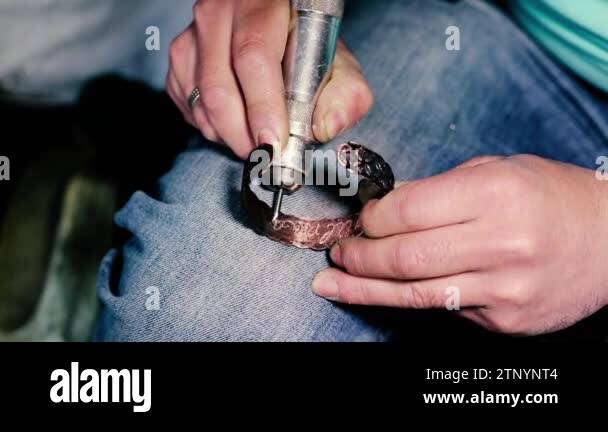 Traditional tinsmith work. Copper smith makes embossing artifacts from ...