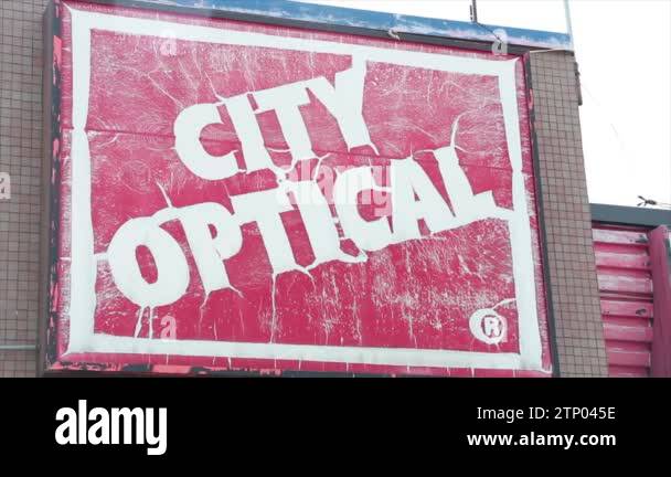 city optical logo sign store storefront red white on store writing ...