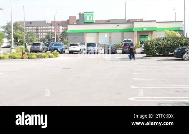 td toronto dominion bank with parking lot wide shot with person walking ...