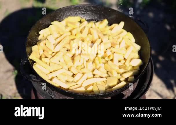Man hand salting a dish. Cooking homemade fried potatoes frying pan in ...