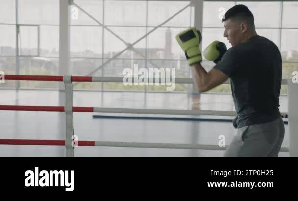 Skilled boxer practicing punches hitting air shadow fighting in boxing ...