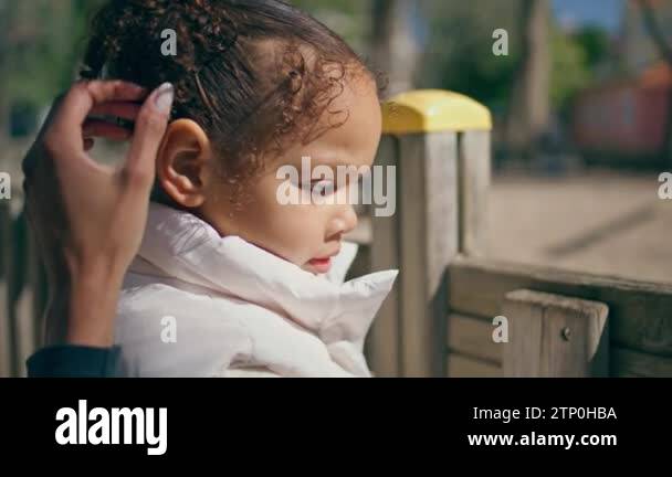 African american child standing near park fence close up. Unknown ...