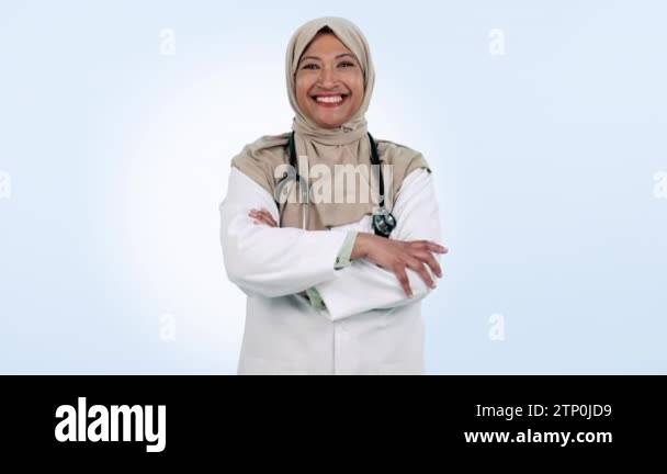 Medical doctor, happy muslim woman and arms crossed in studio for ...