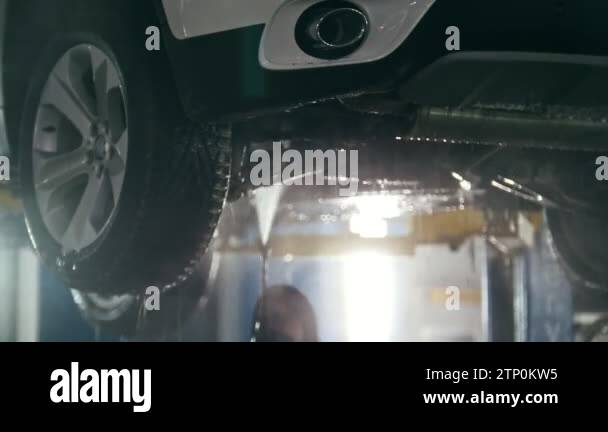 Washing luxury SUV under bottom in the suds by water hoses - under ...