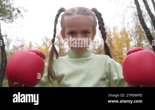 Little girl kid kicks boxing gloves one another making funny silly ...
