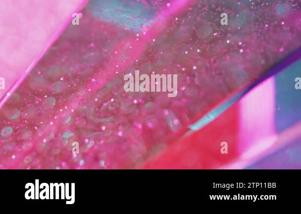 Glitter flow background. Magic liquid. Pink green shiny shimmer water with bokeh round spots ...