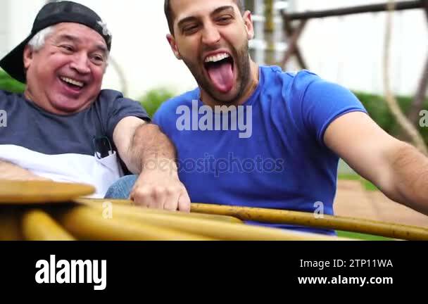 Dad and son playing on roundabout Stock Video Footage - Alamy