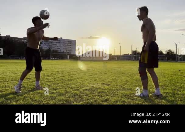 Two sportsmen showing tricks with ball while passing it to each other ...