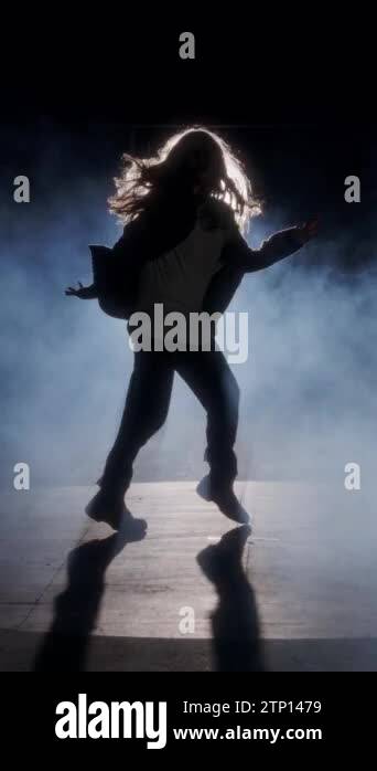 Dancer performing hip hop dance in slow motion with light and smoke ...