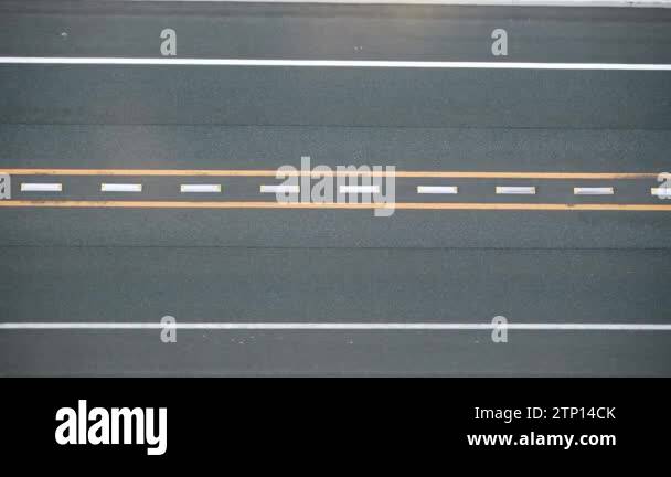 Aerial view captured by a drone showing a road with cars passing ...