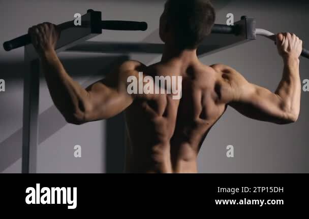 rolled man performs pull-UPS closeup in the gym. You can see all the ...